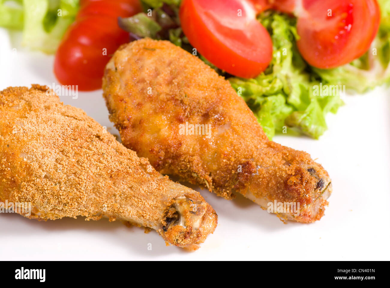 Fried chicken legs served with salad Stock Photo - Alamy