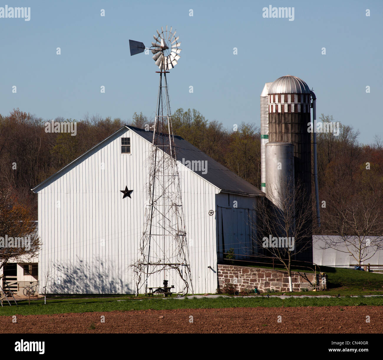 A water pumping windmill in front of an Amish white barn Stock Photo ...