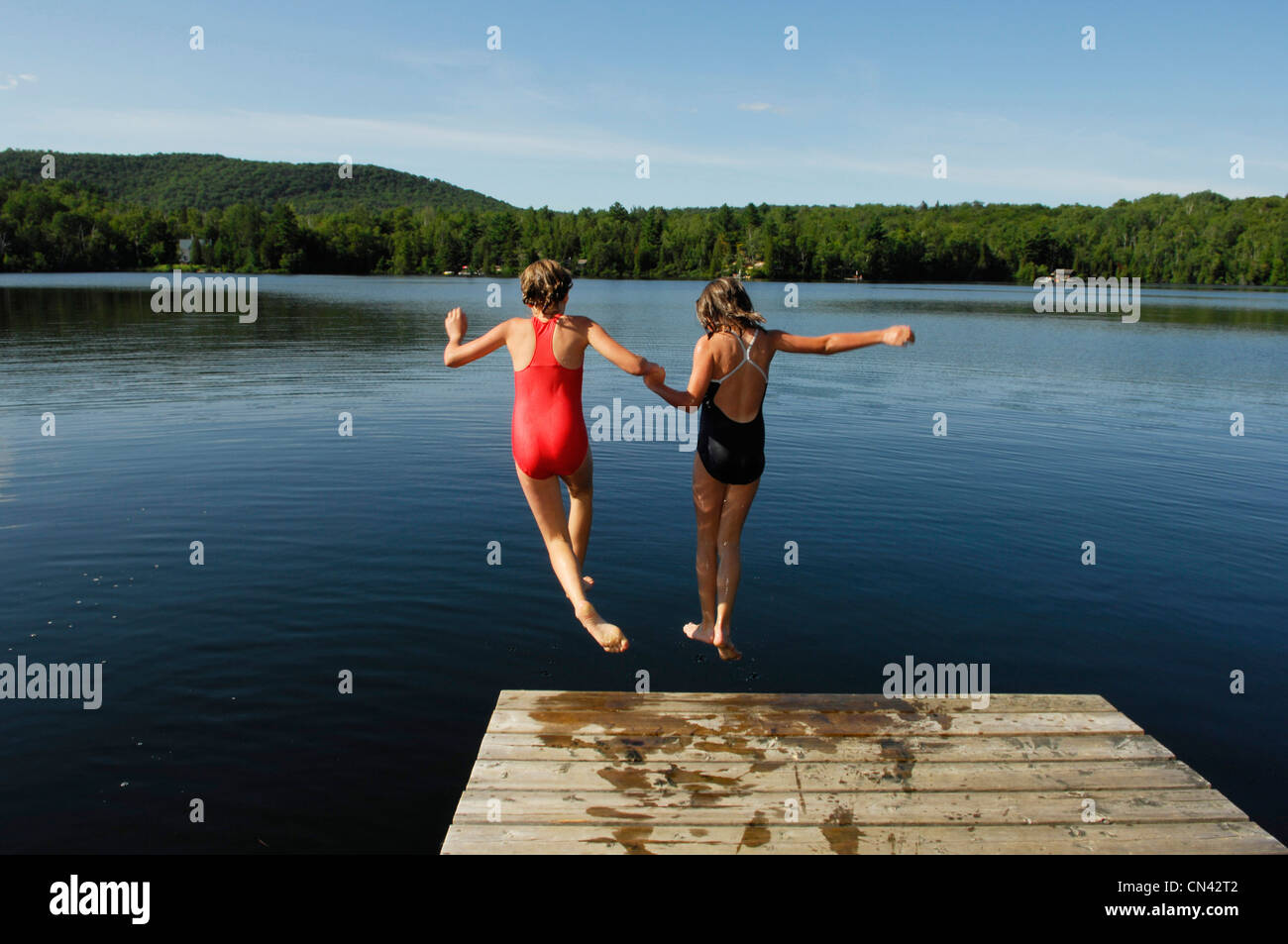 Young Girls Jumping off a Dock, Lac des Neiges, Quebec Stock Photo - Alamy