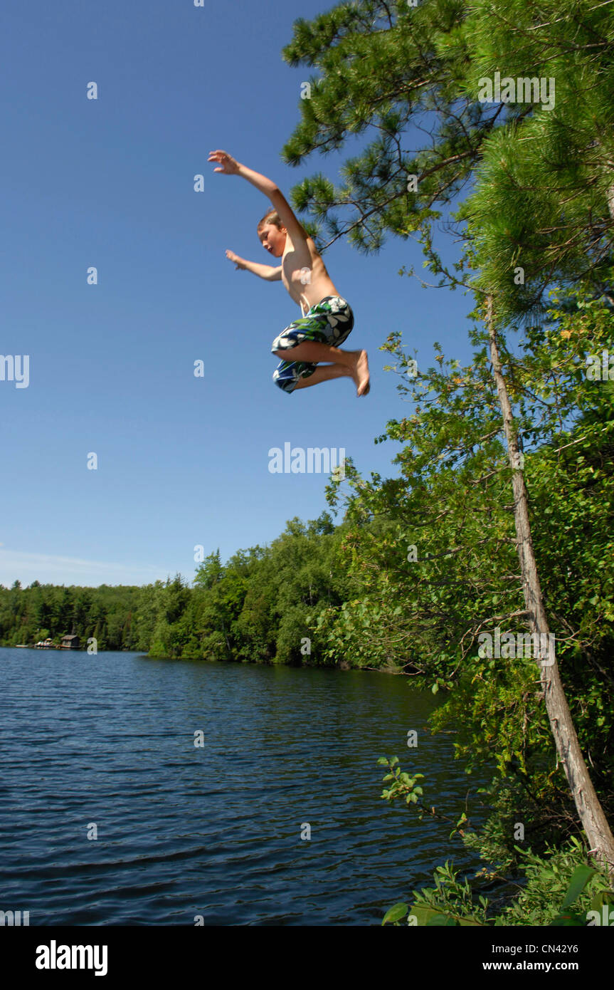 Young Boy Jumping off a Cliff into Lake, Lac des Neiges, Quebec Stock ...