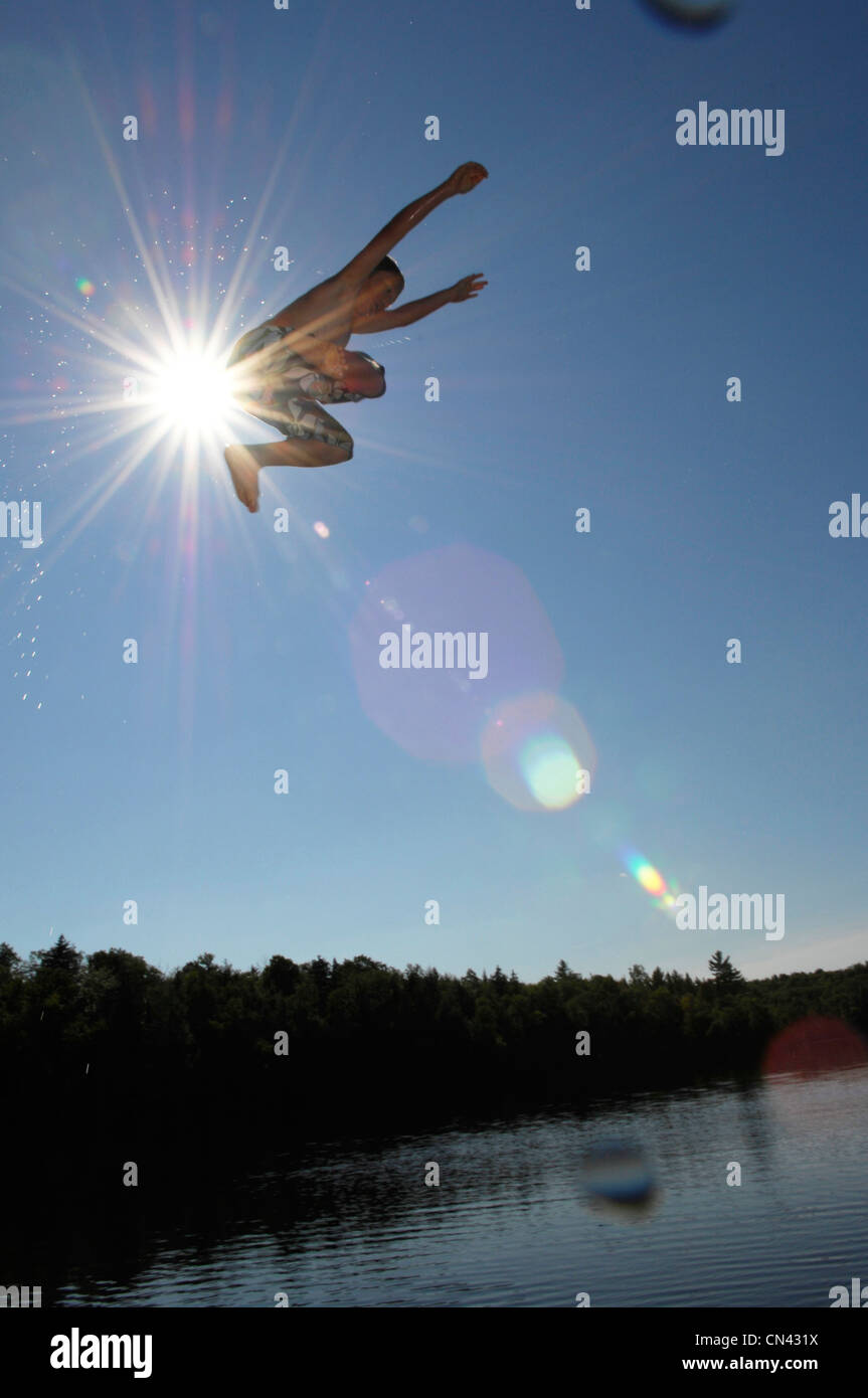 Young Boy Jumping off a Dock with Sunlight behind him, Lac des Neiges ...