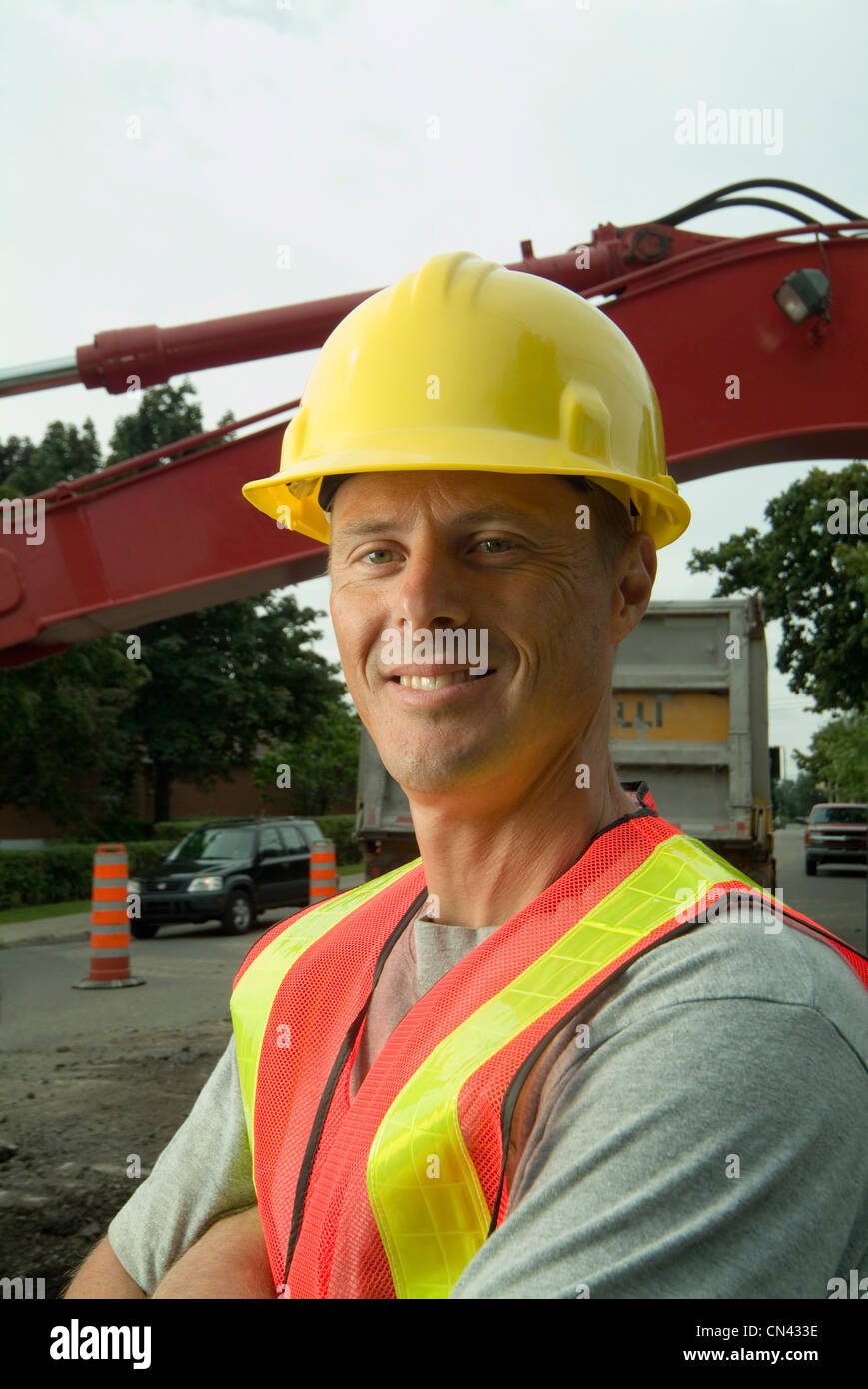 Construction Worker Smiling with Arms Crossed in front of a Front ...