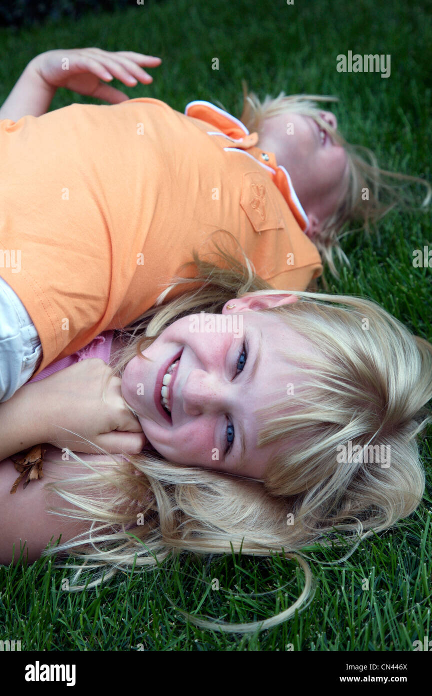 Sisters Playing on Grass Stock Photo - Alamy