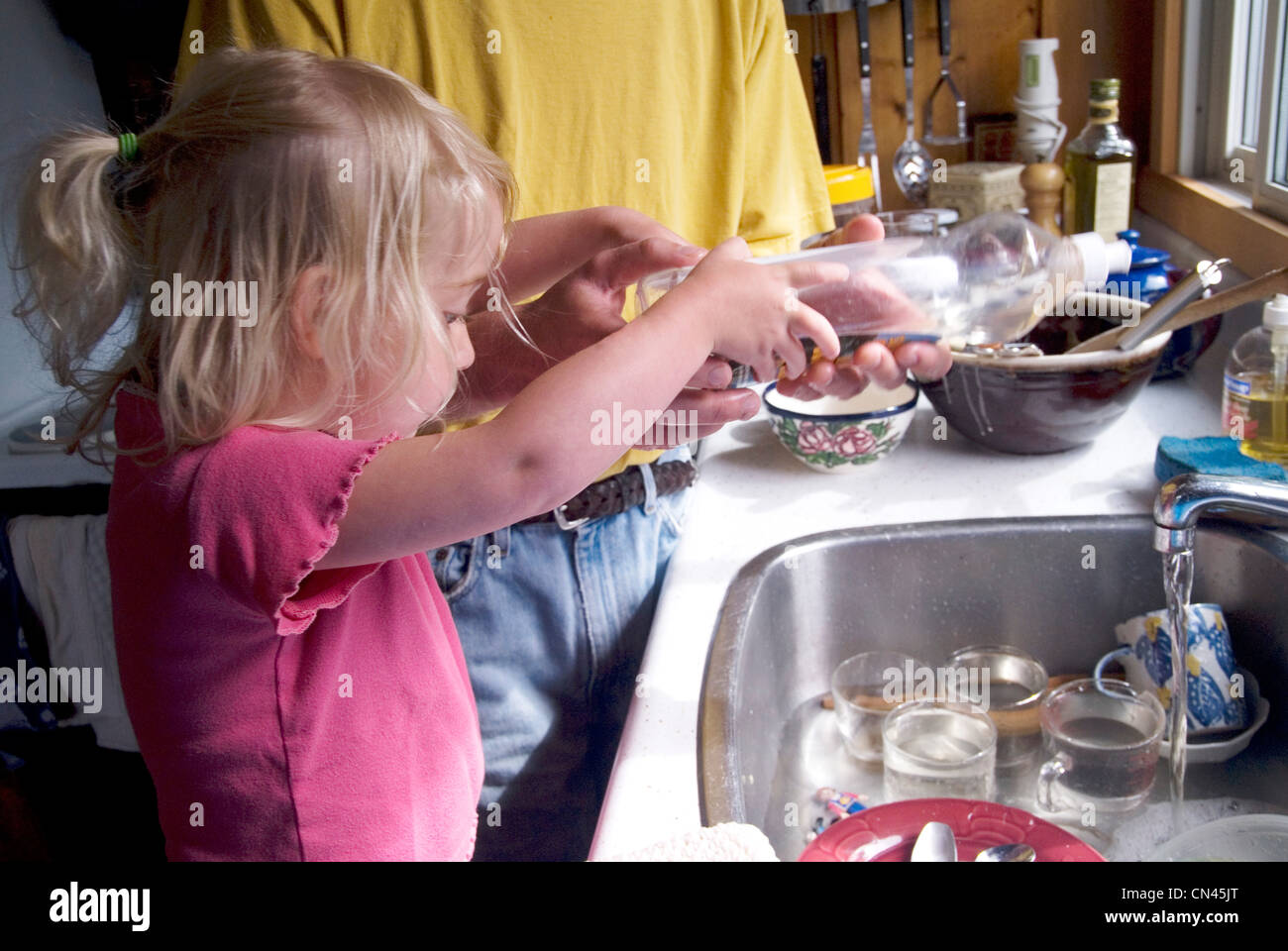 Little Girl Helping her Dad Wash Dishes with Biodegradable Dish Soap ...