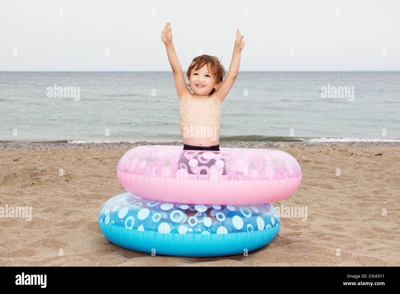 Young Boy Playing with Inner Tubes on a Beach, Toronto, Ontario Stock ...