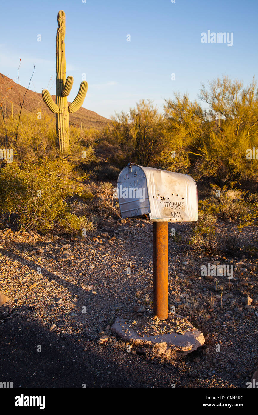 Rural mailbox in desert with bullet holes and "outgoing mail" written ...