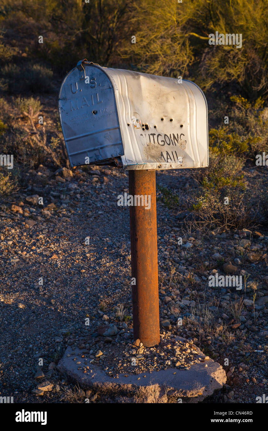 Rural mailbox in desert with bullet holes and "outgoing mail" written ...
