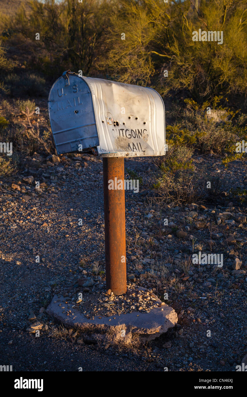 Rural mailbox in desert with bullet holes and "outgoing mail" written ...