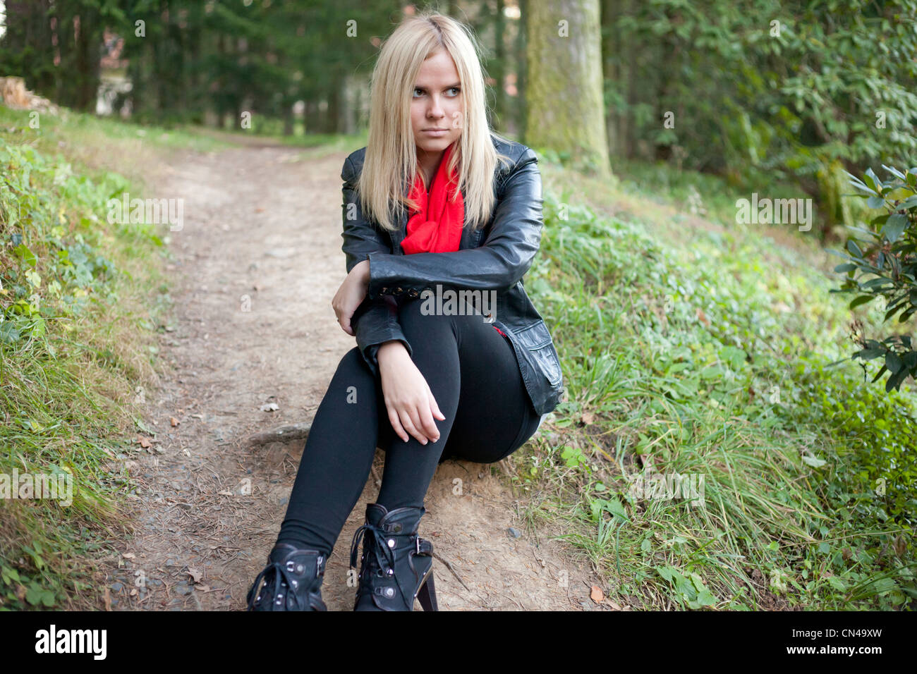Contemplative Woman Seated on a Forest Trail Stock Photo - Alamy