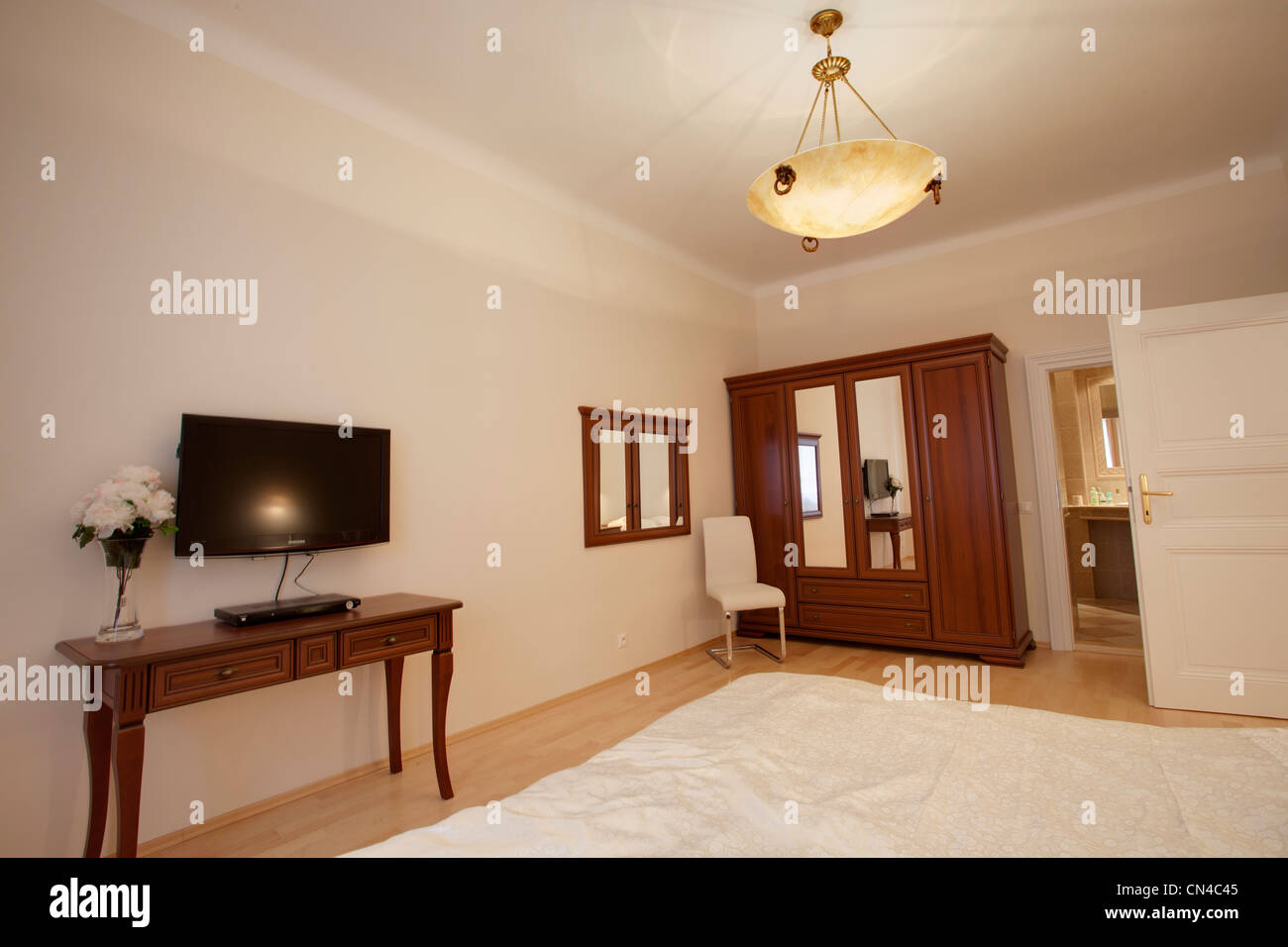 Elegantly furnished room with a flat-screen TV, wooden wardrobe, and a ...