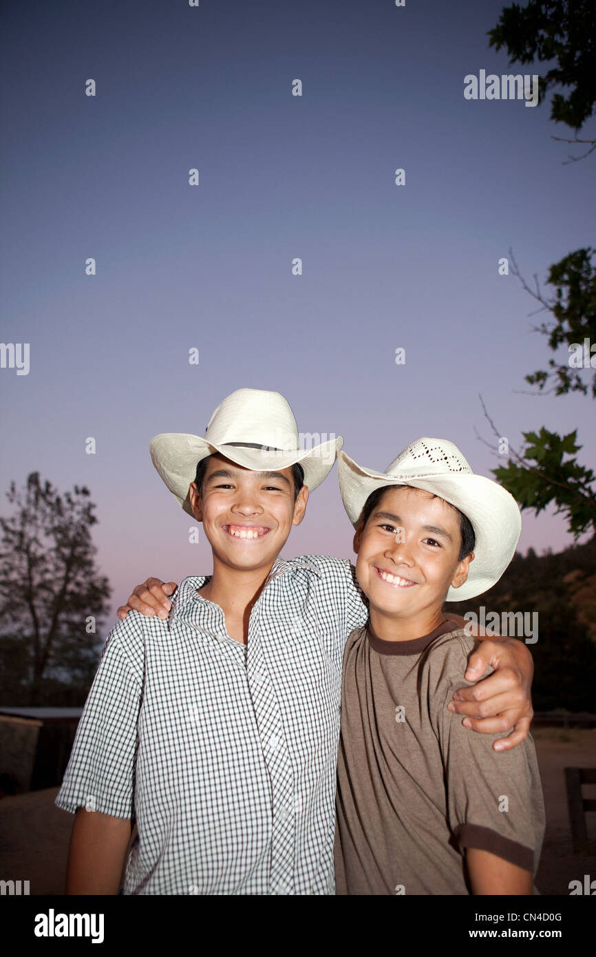 Brothers wearing cowboy hats and smiling, portrait Stock Photo - Alamy