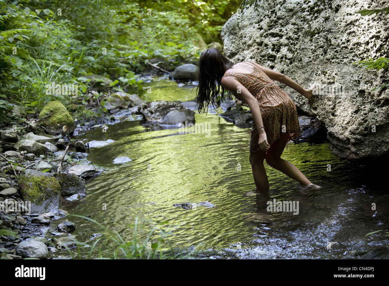 Teenage girl walking into stream Stock Photo - Alamy