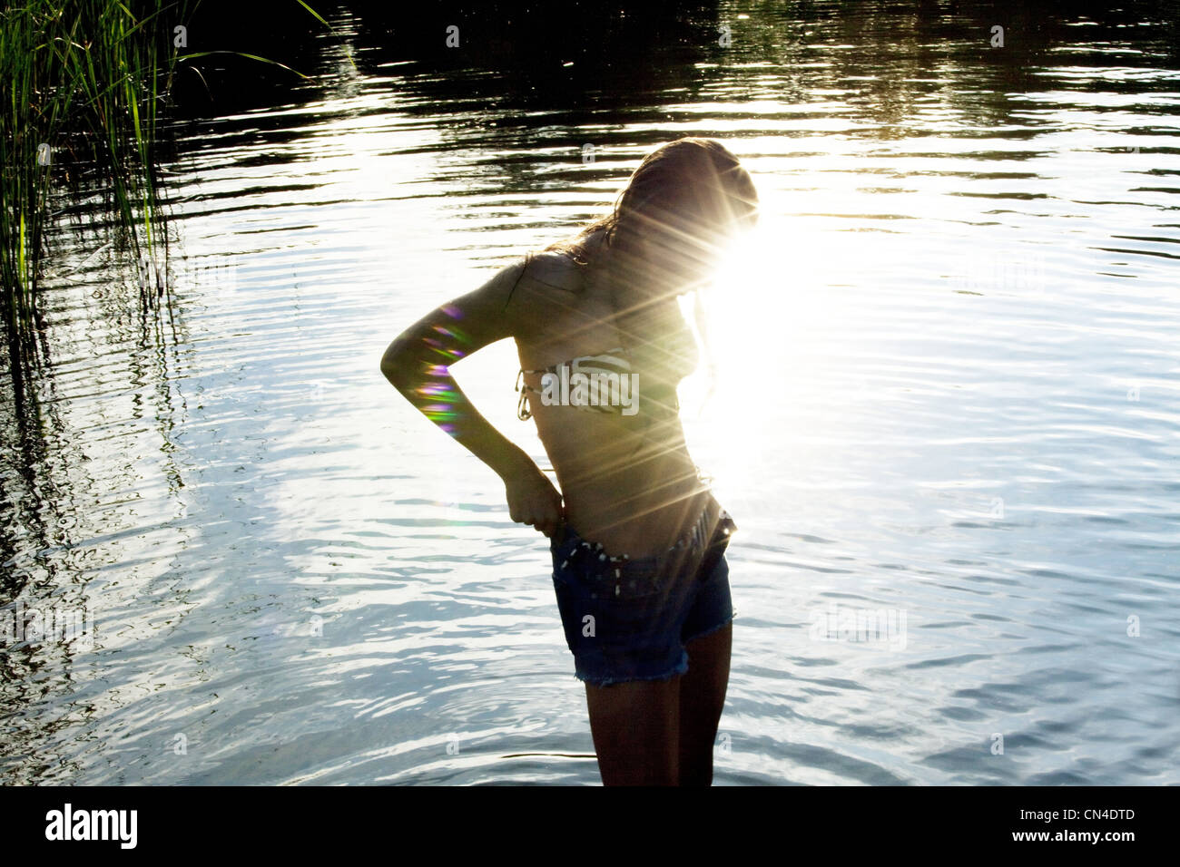 Teenage girl standing in sunlit river Stock Photo - Alamy