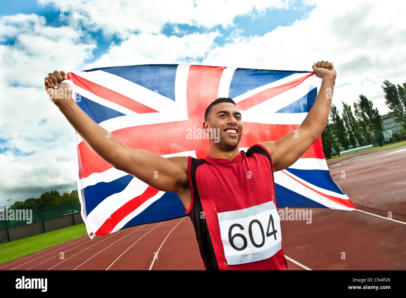 Sprinter holding Union flag on sportstrack Stock Photo - Alamy