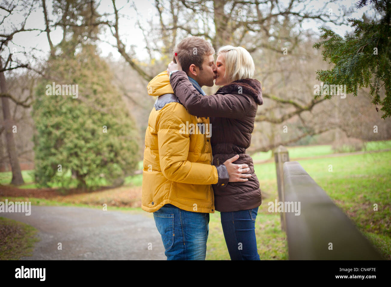 Couple kissing outside in a park Stock Photo - Alamy
