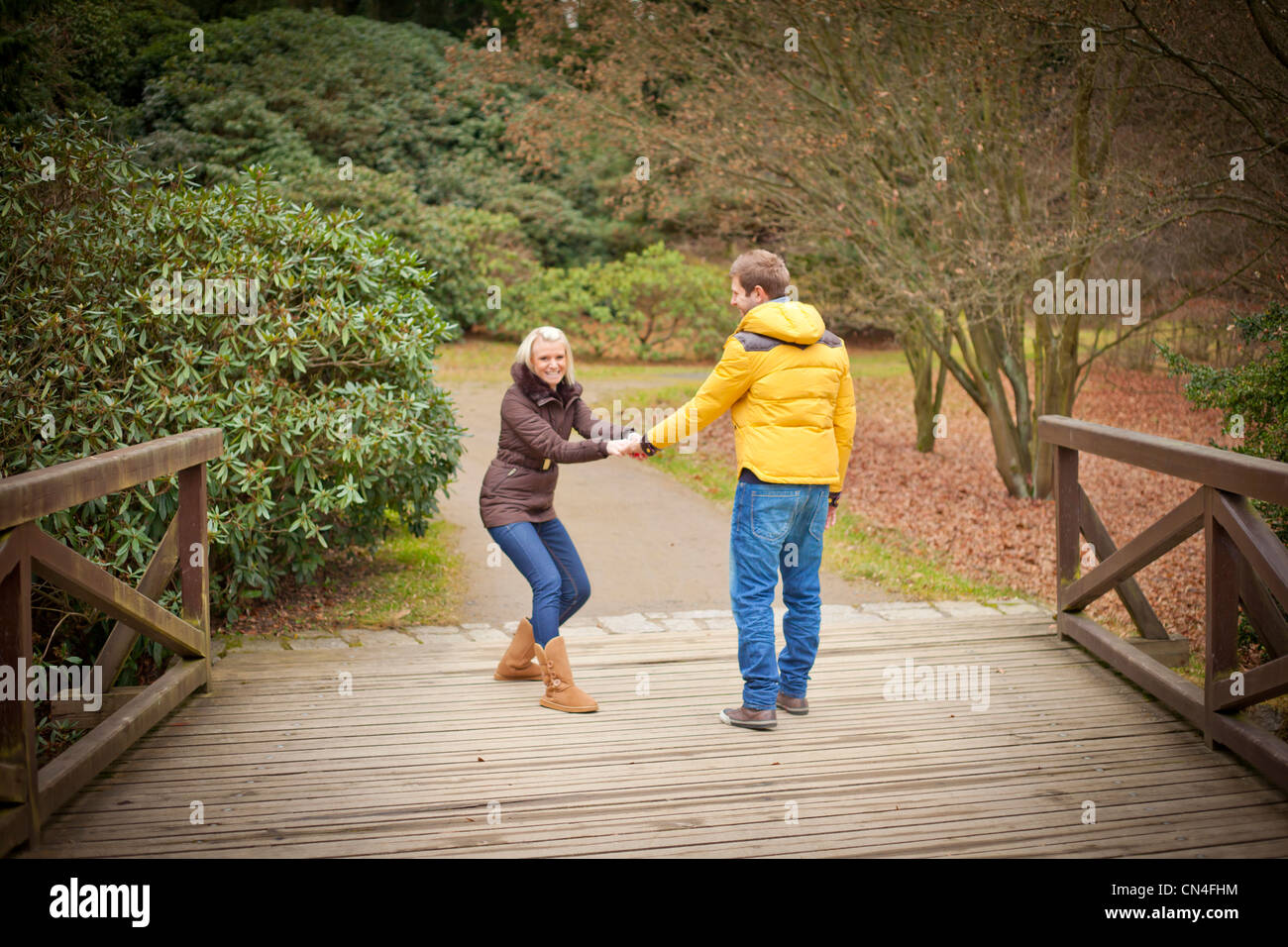 Playful Couple Teasing Each Other on a Wooden Bridge in the Park Stock ...
