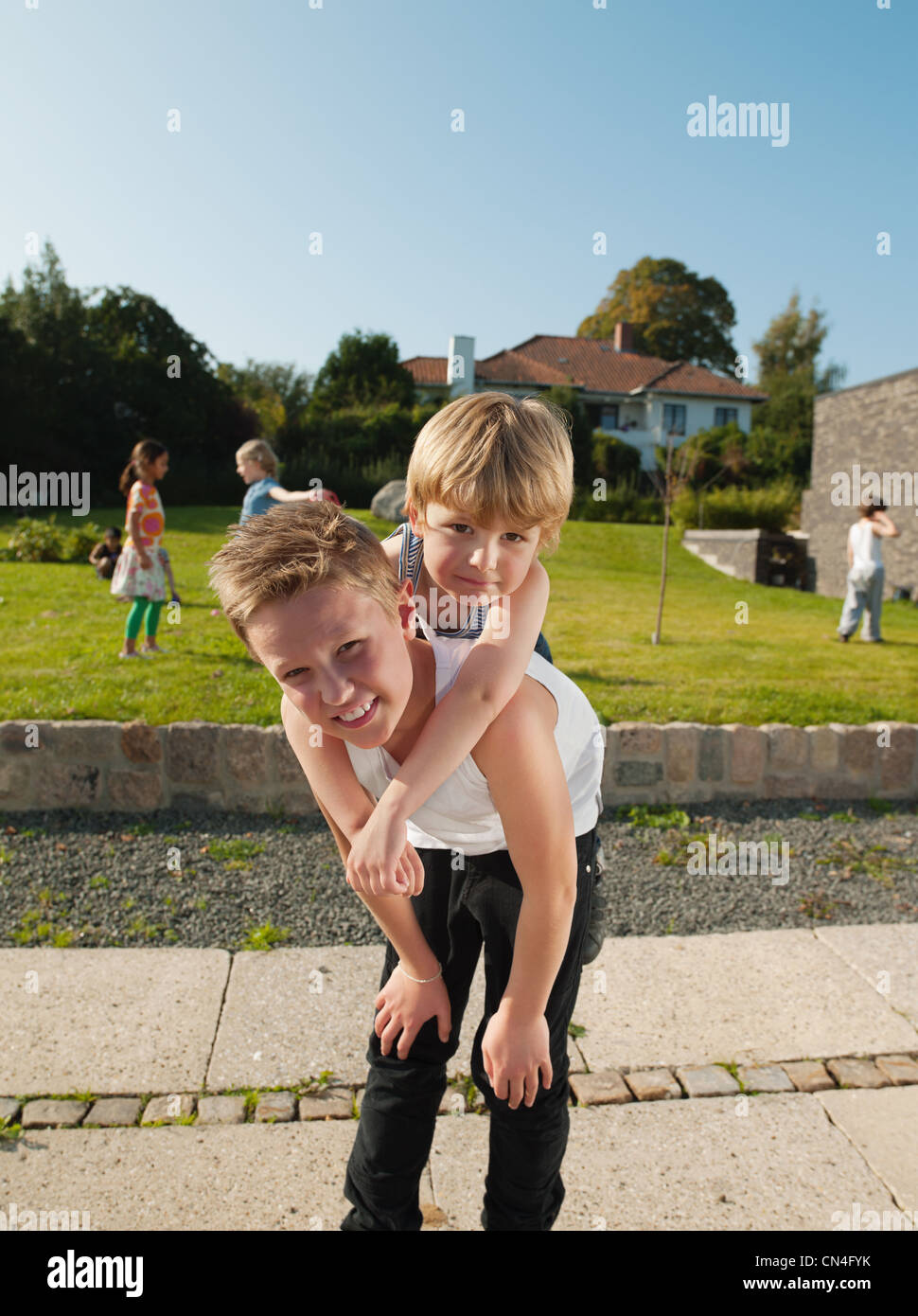Boy giving brother piggyback, portrait Stock Photo - Alamy