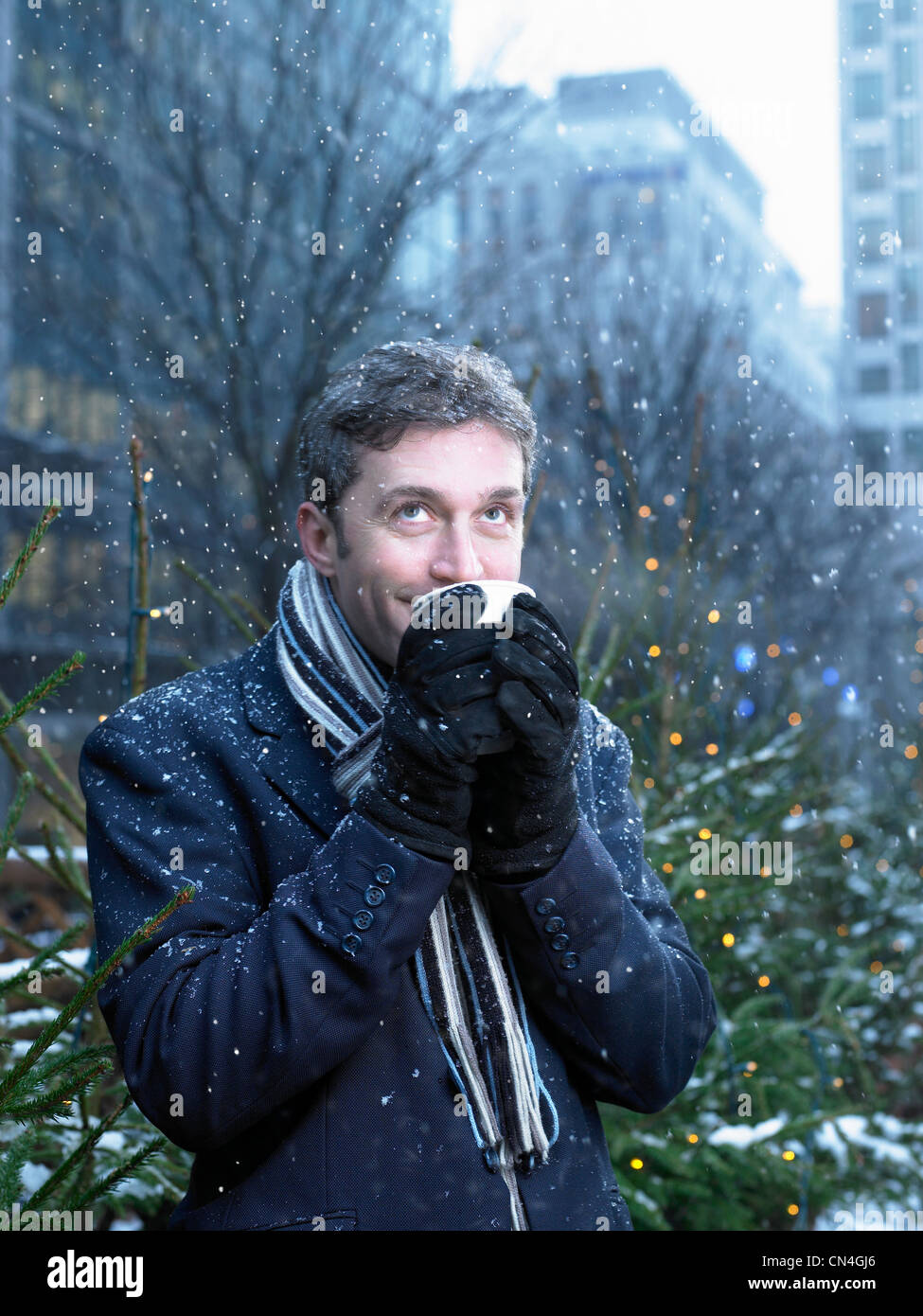 Man watching the snow while sipping drink Stock Photo - Alamy