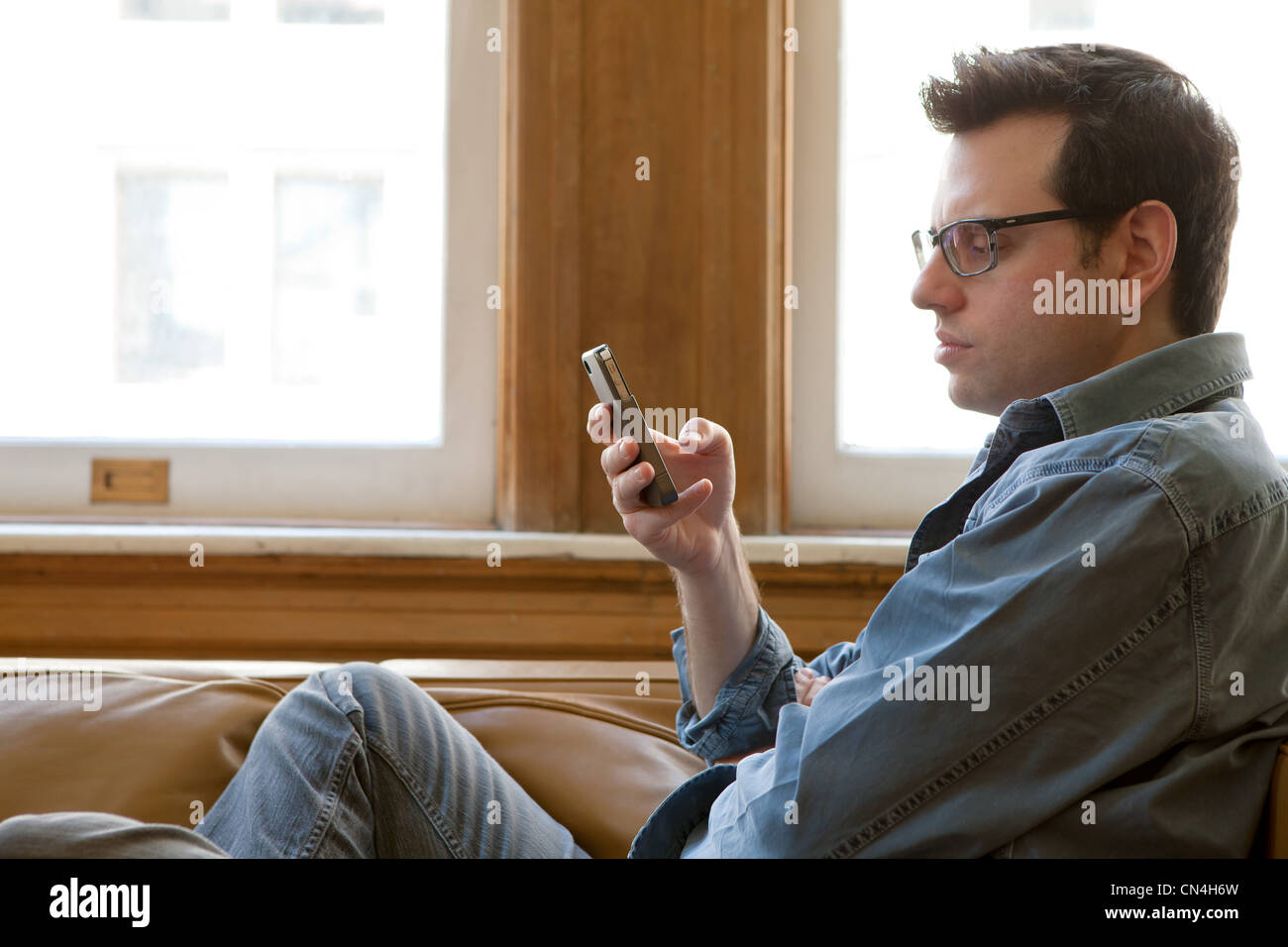 Mid adult man using smartphone, side view Stock Photo - Alamy
