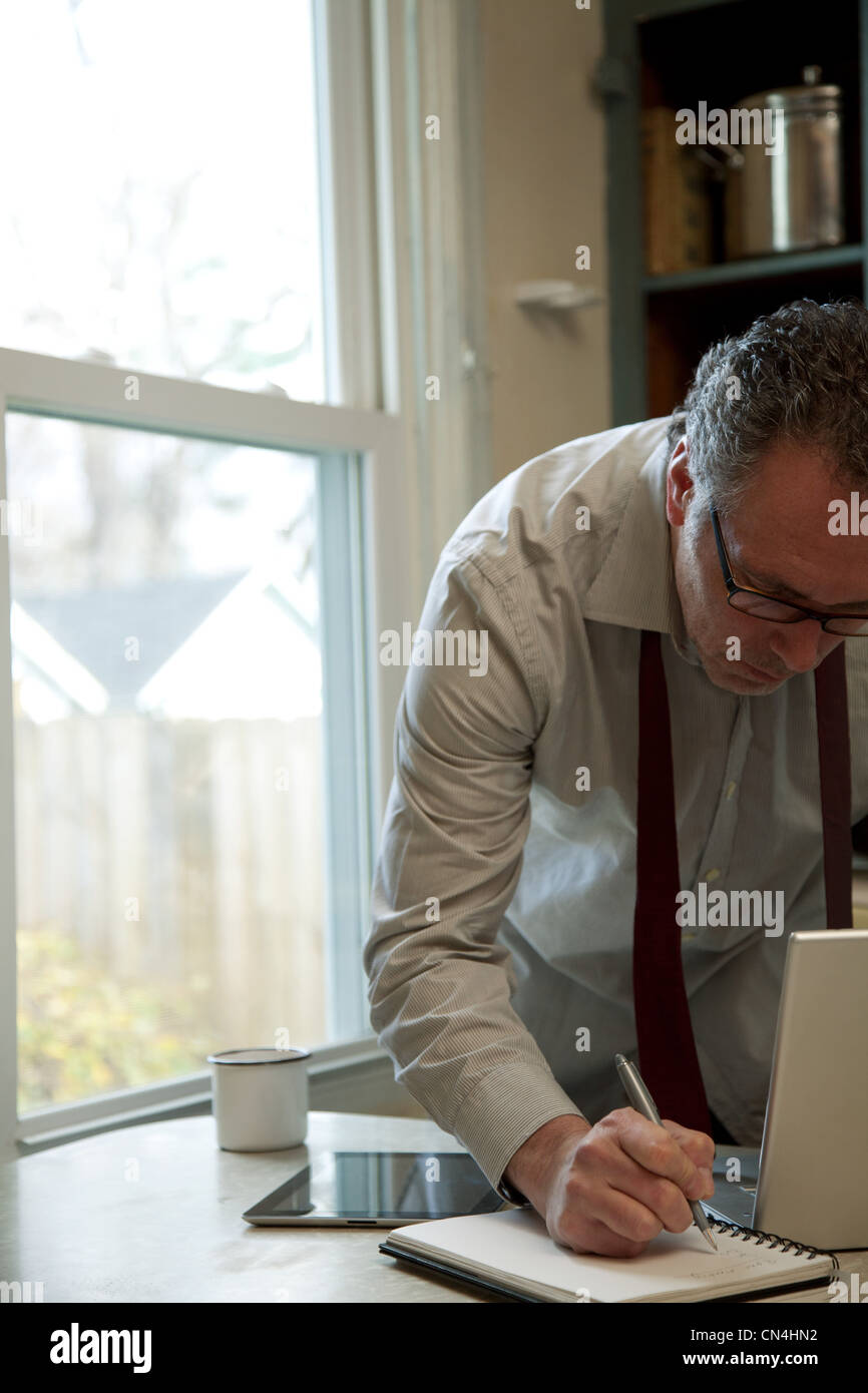 Mature adult home laptop taking notes hi-res stock photography and ...