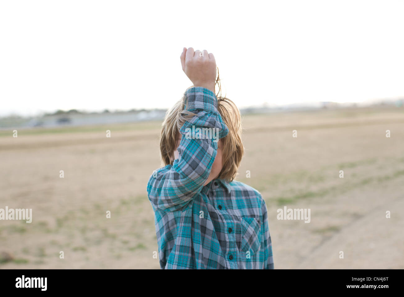 Boy with arm in front of face Stock Photo - Alamy