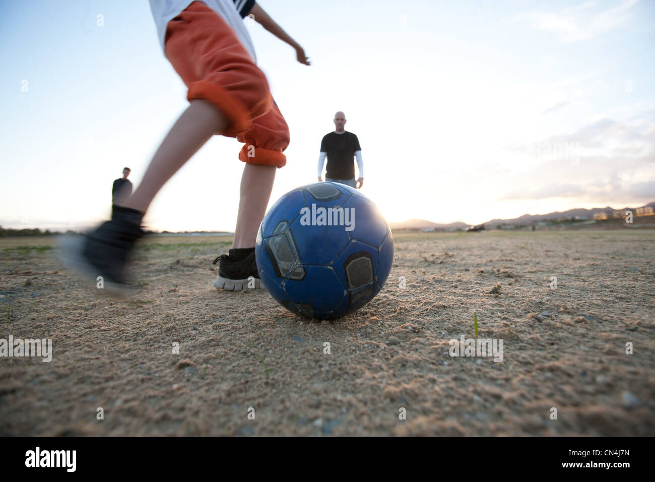 Kicking soccer ball hi-res stock photography and images - Alamy