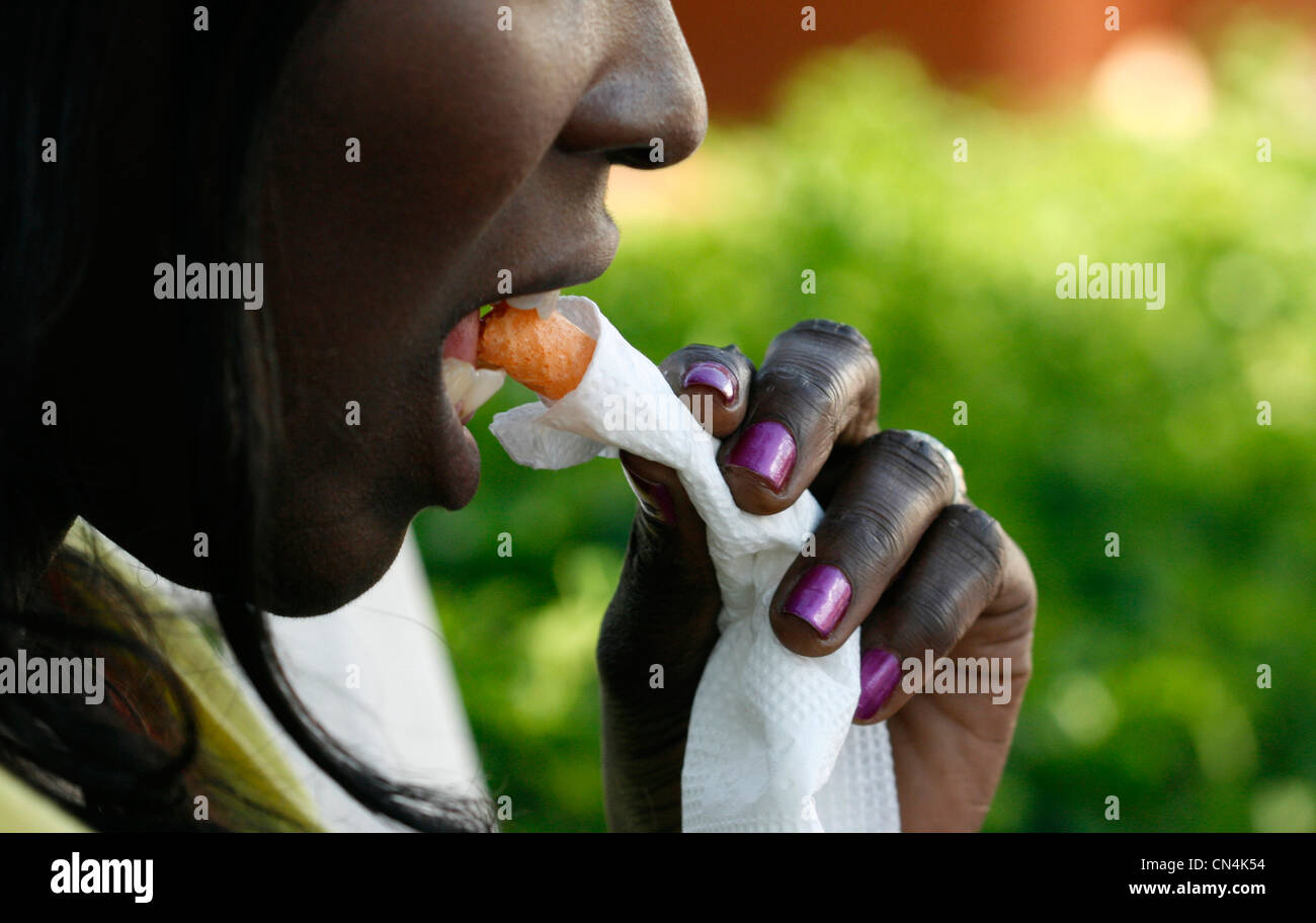 A young African woman eating a snack Stock Photo - Alamy