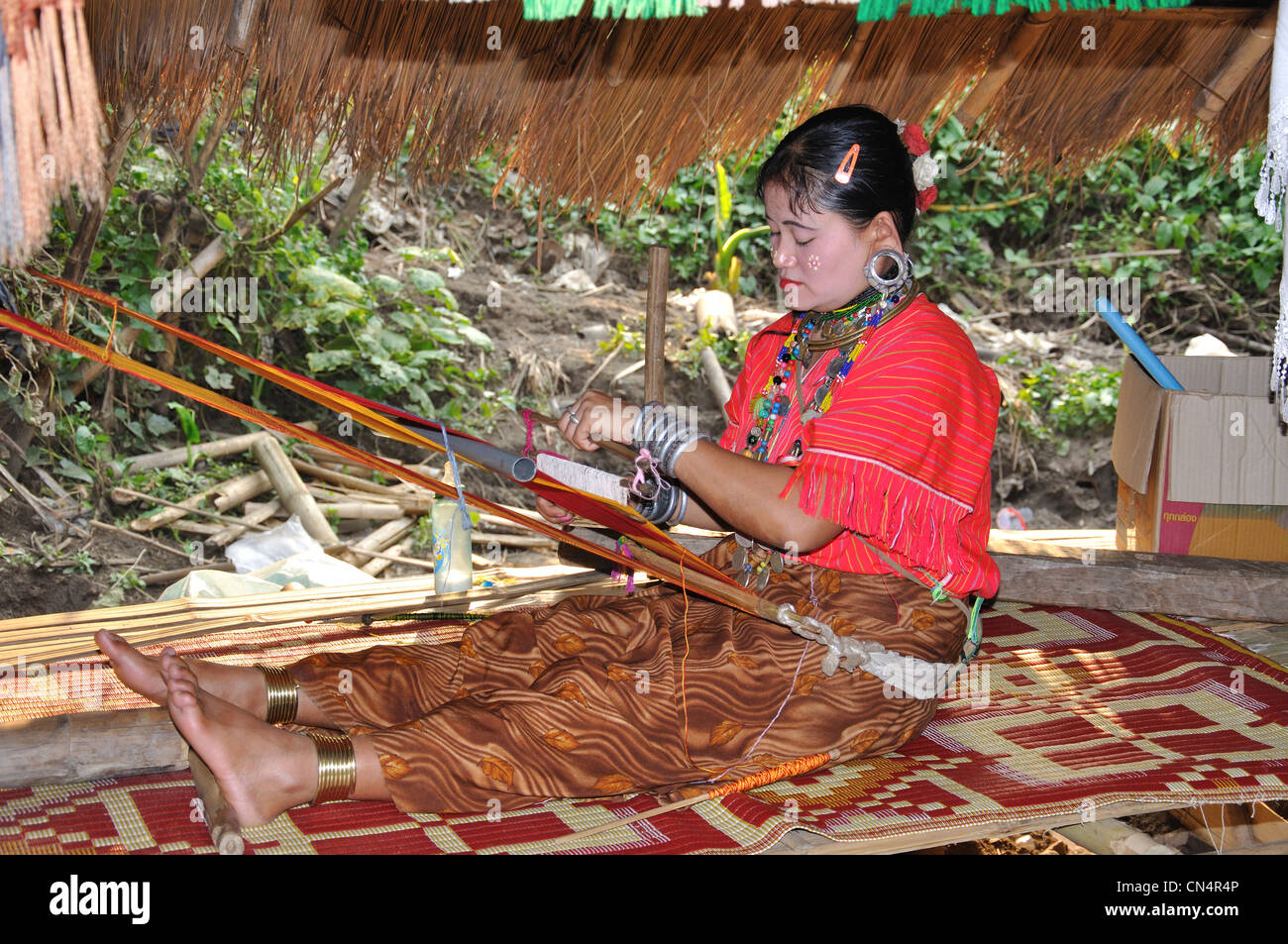 A Kayan Lahwi woman weaving at Karen Long Neck hill tribe village ...
