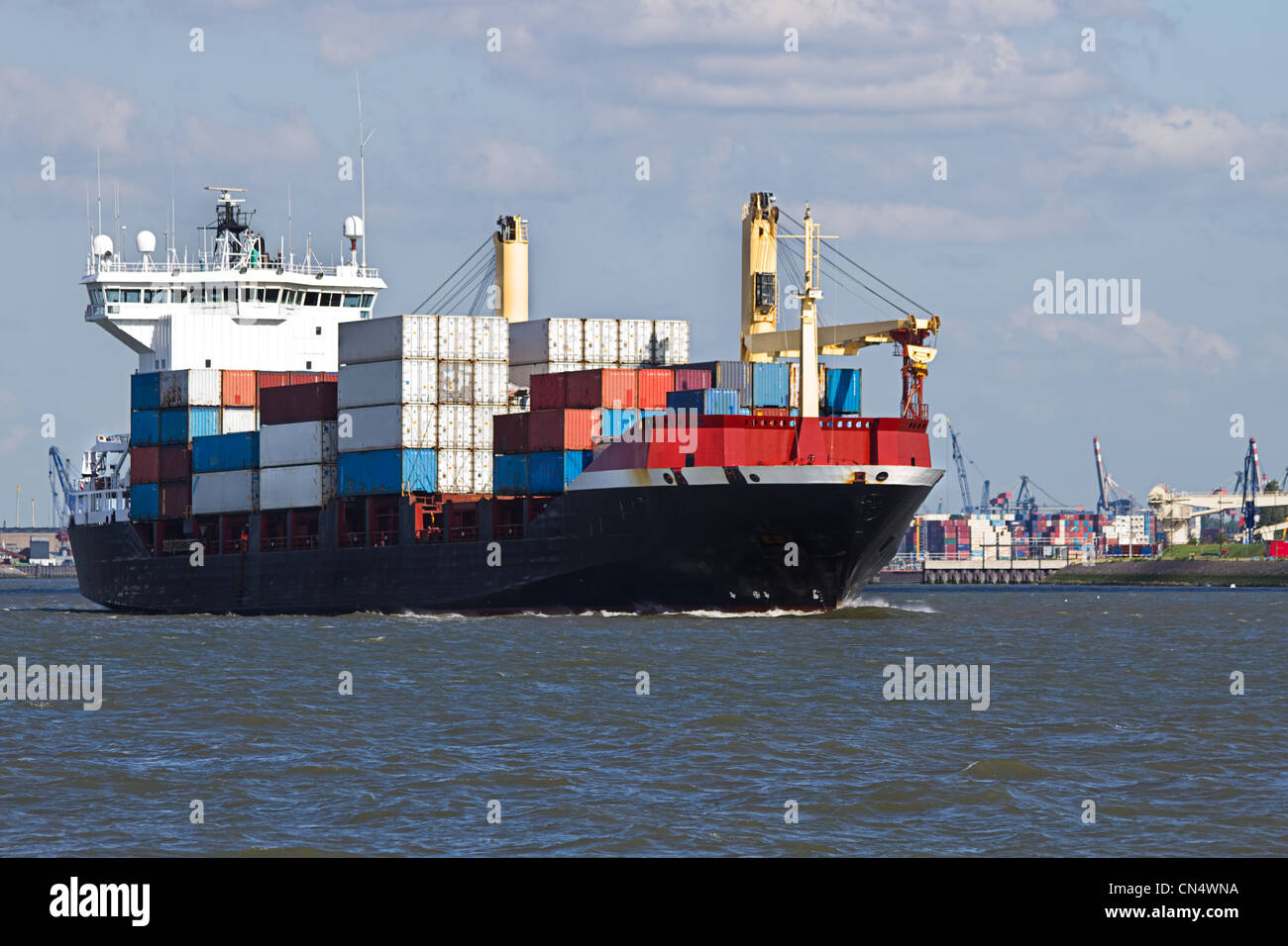 Containership leaving port with container harbor in background Stock ...