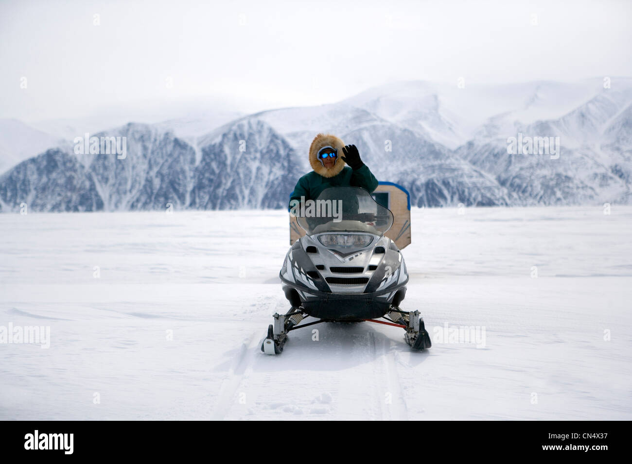 Inuit Man waving from a Skidoo, on the Ice between Baffin and Bylot ...
