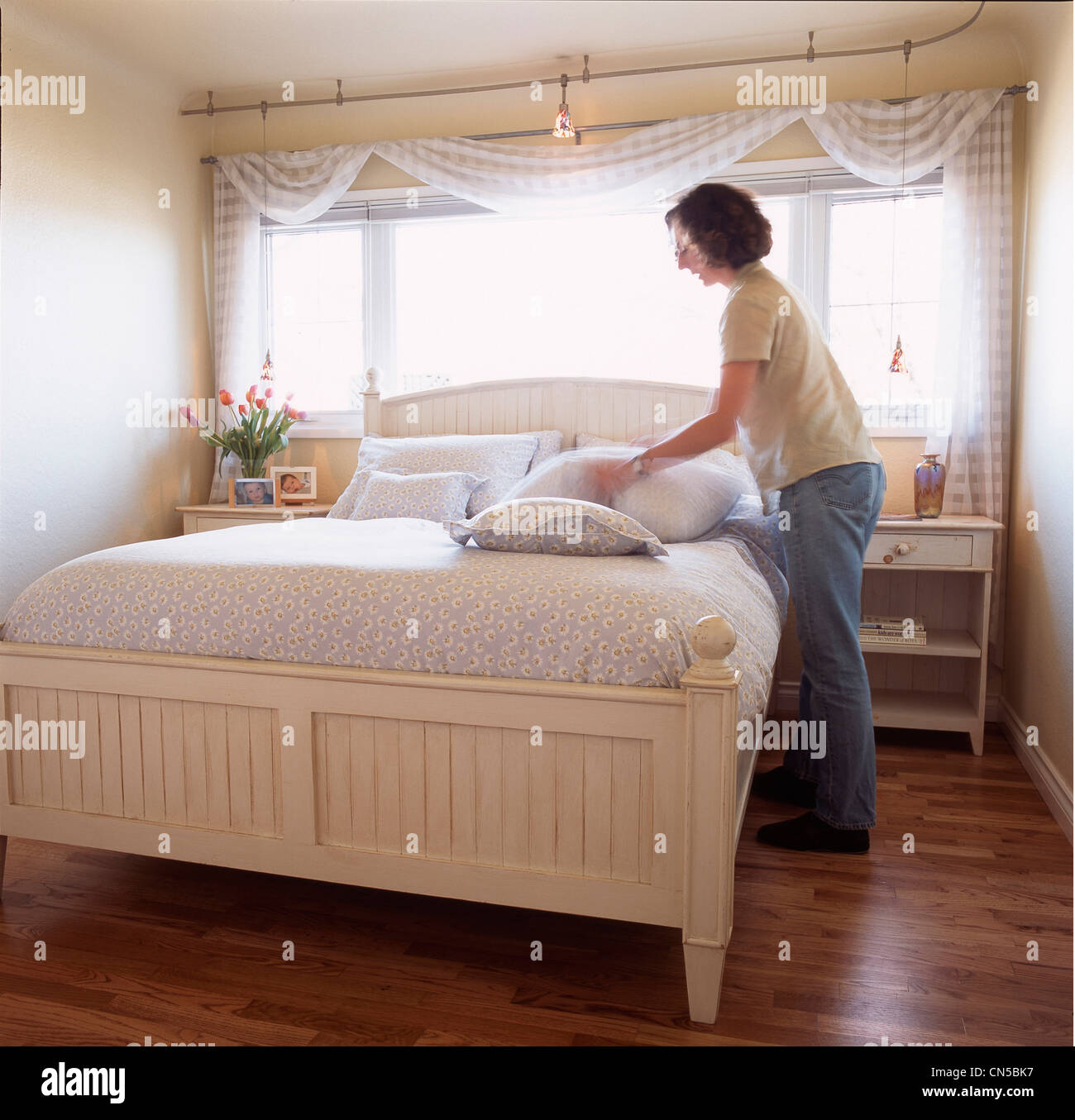 Woman fluffing pillows hi-res stock photography and images - Alamy