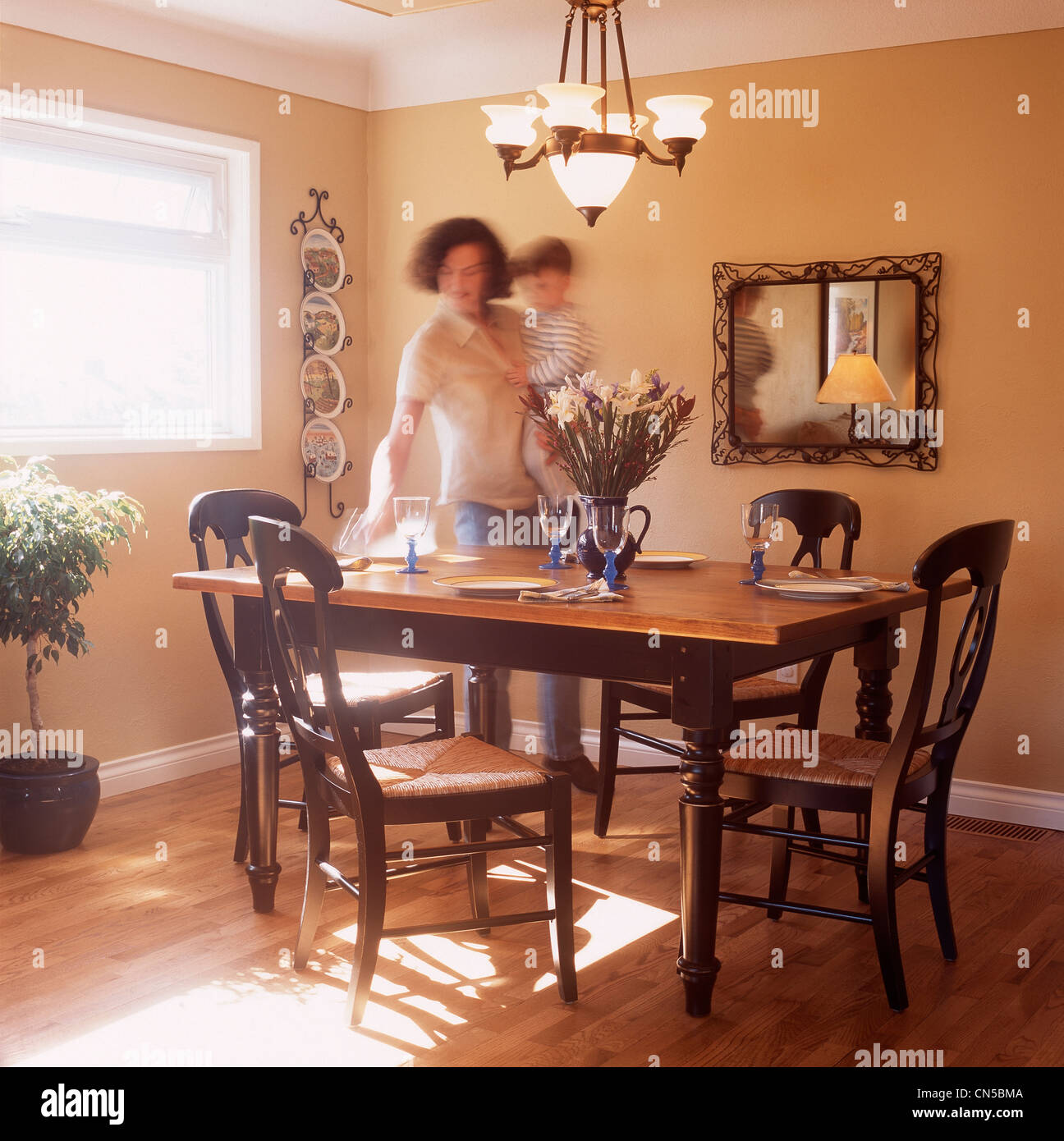 Woman Holding Child while Setting Dinner Table, Victoria, British ...