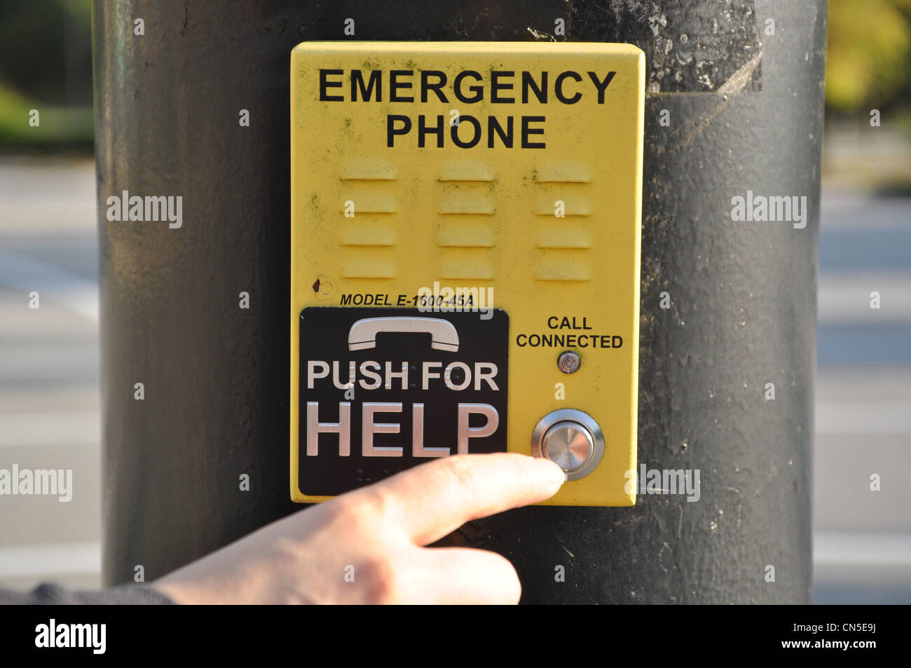 Pushing emergency phone for help Stock Photo - Alamy
