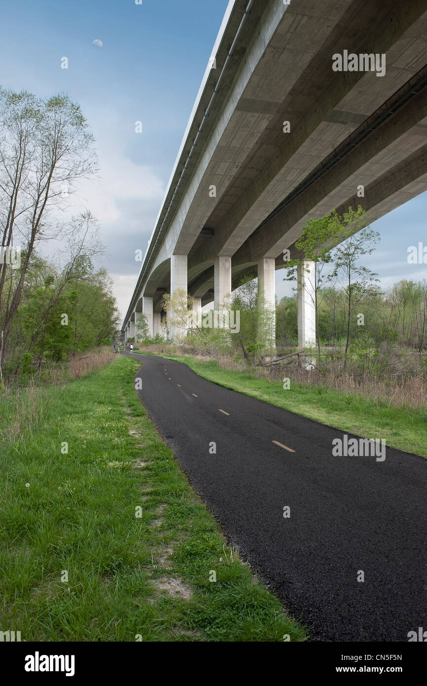 A huge, elevated highway and a small paved walking path seem at home in ...