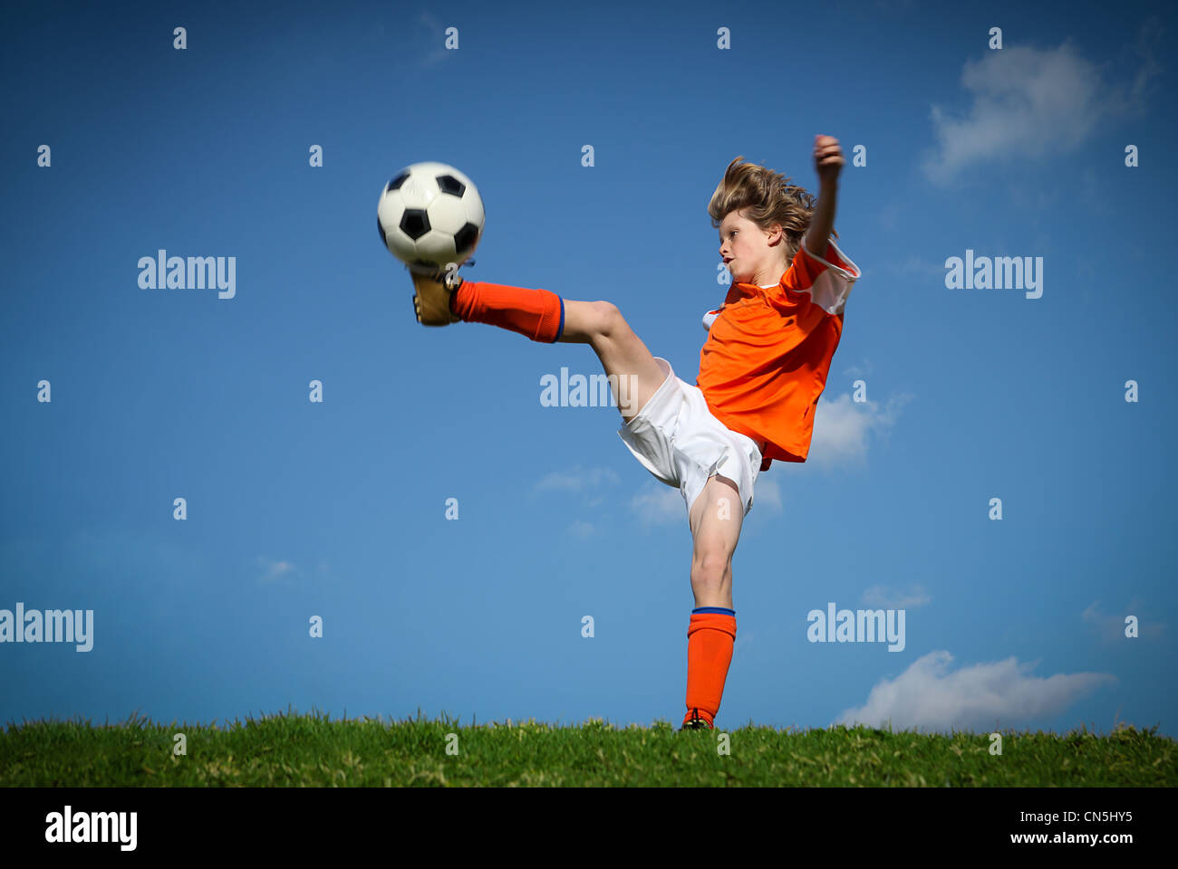 Child kicking playing football Stock Photo - Alamy