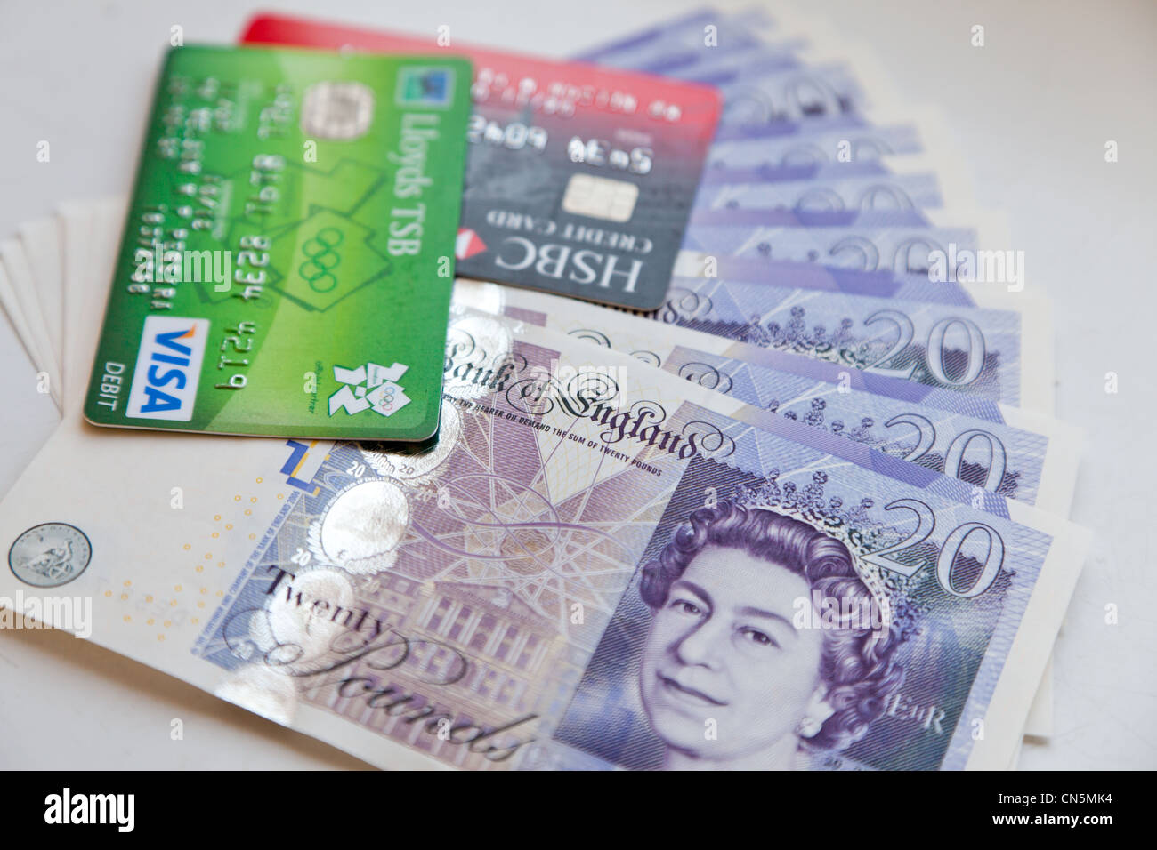 A set of twenty pound notes with two bank cards on top Stock Photo - Alamy