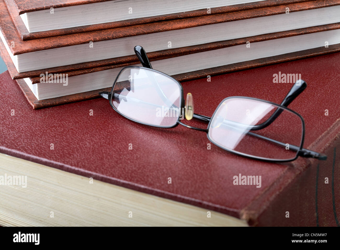 Pile of books and glasses on old thick volume Stock Photo - Alamy