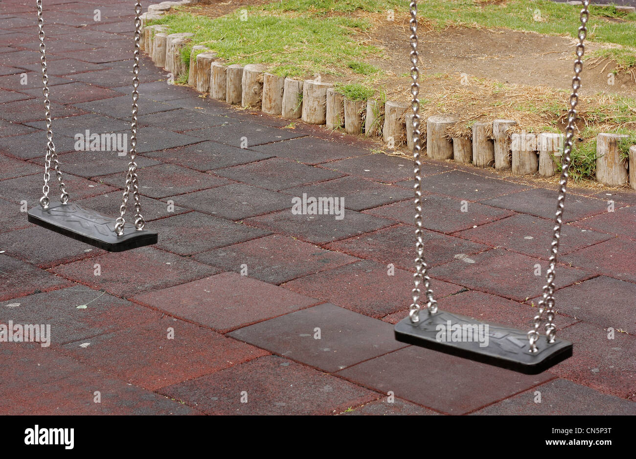 Two swings in a playground Stock Photo - Alamy