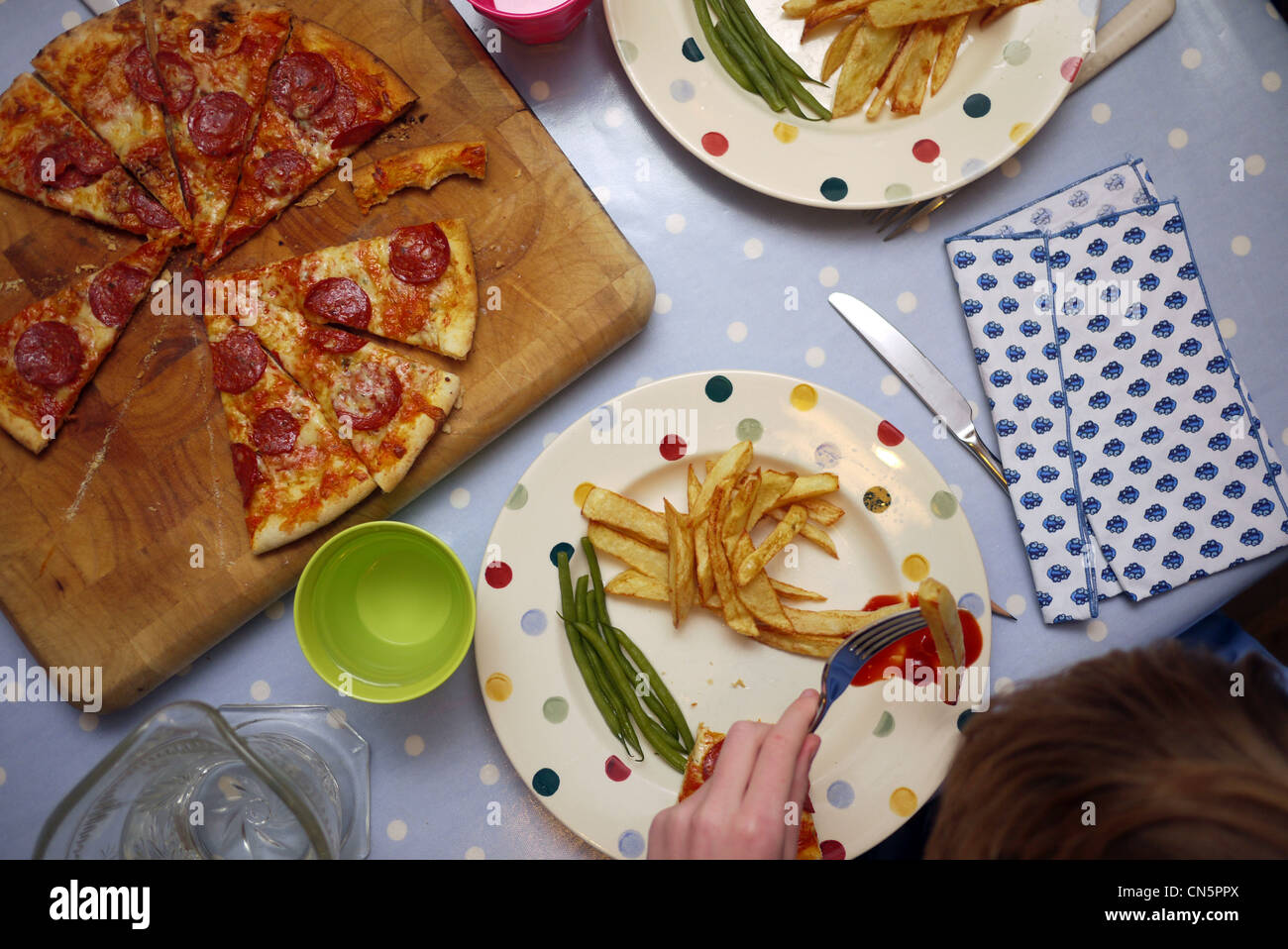 Children eating tea of pizza and chips Stock Photo - Alamy