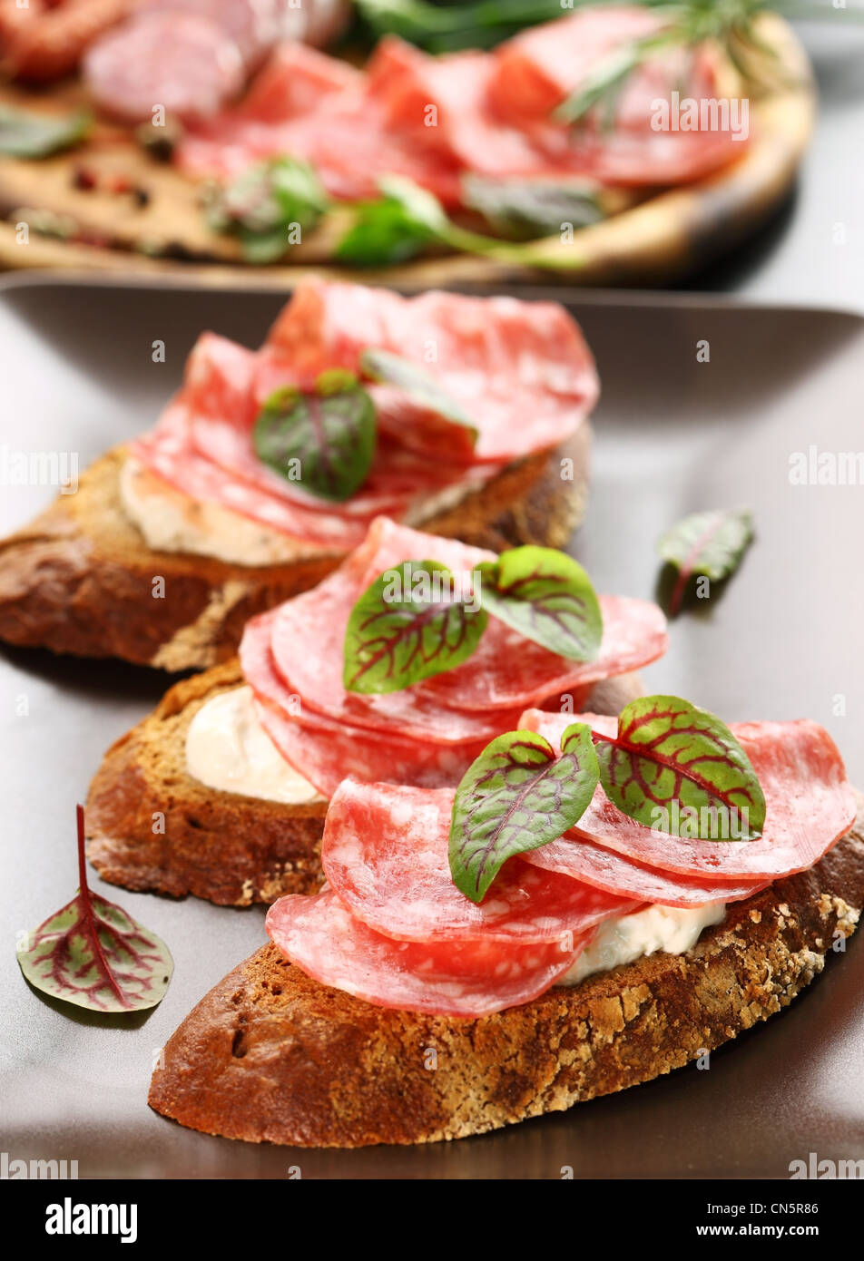 Canape with cream cheese, salami and herbs Stock Photo - Alamy