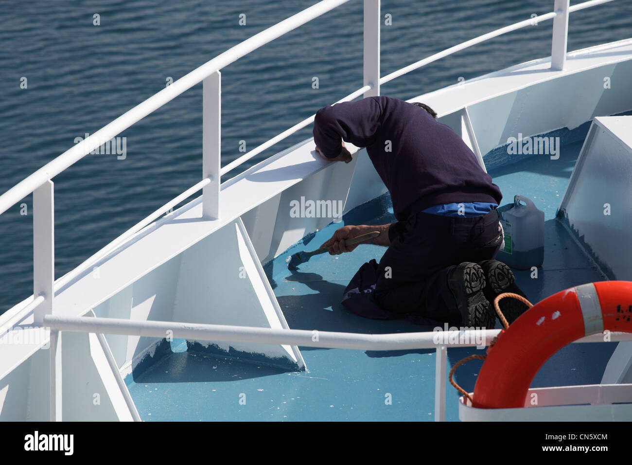 A deckhand on the Malta - Gozo ferry paints the deck Stock Photo - Alamy