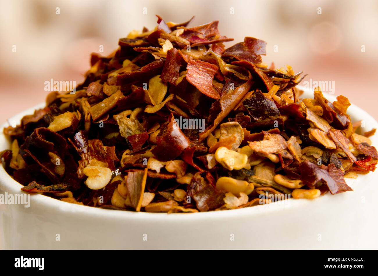 chilli flakes in a white bowl Stock Photo - Alamy