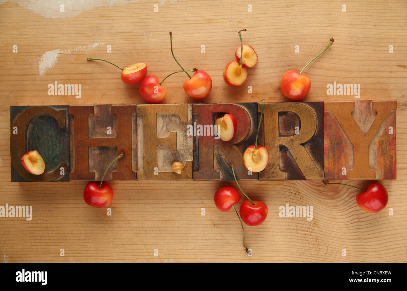 the word cherry in old wood type surrounded by fresh cherries Stock ...