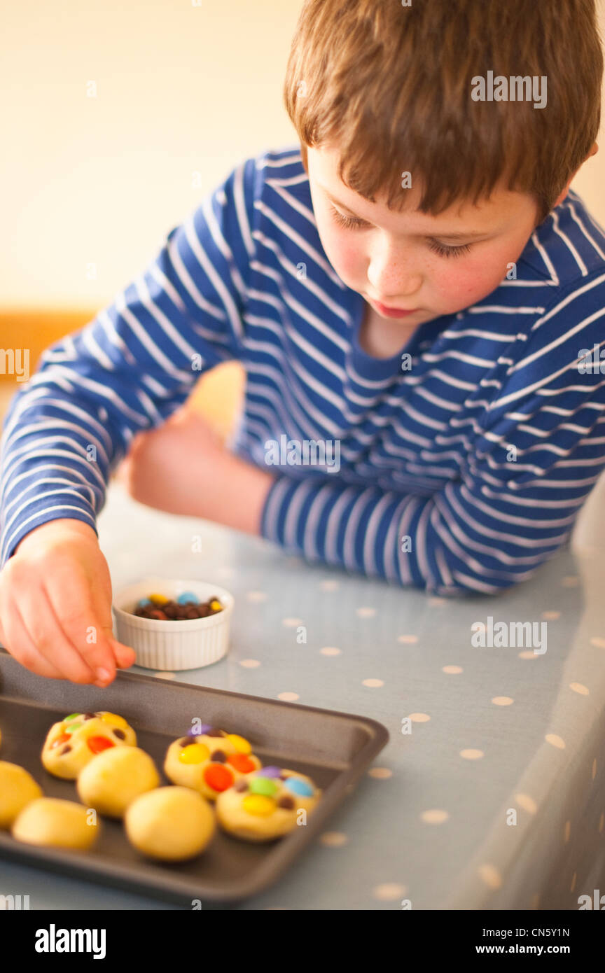 An 8 year old boy making cookies at home in England , Britain , Uk ...