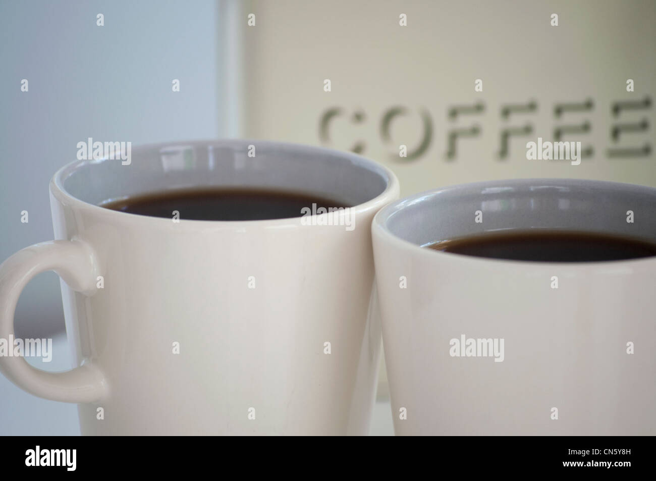 Two mugs of coffee and a coffee tin Stock Photo - Alamy