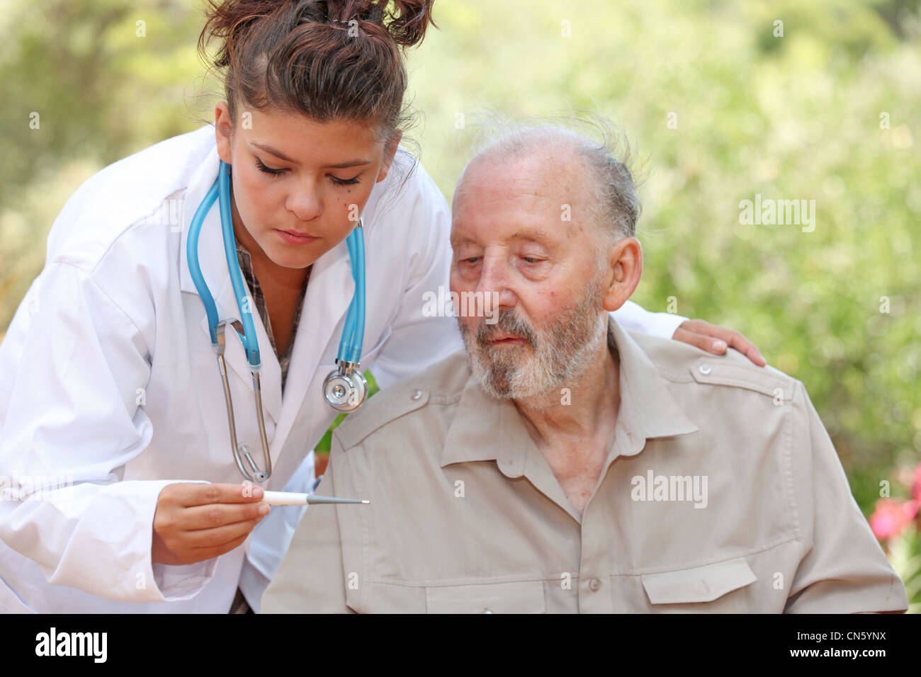 nurse or doctor taking temperature of senior ill patient Stock Photo ...