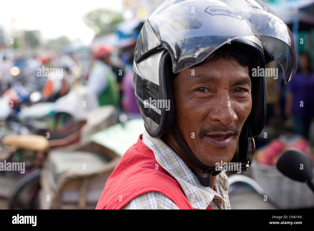 A motorcycle taxi driver waiting for trade outside the Central market ...