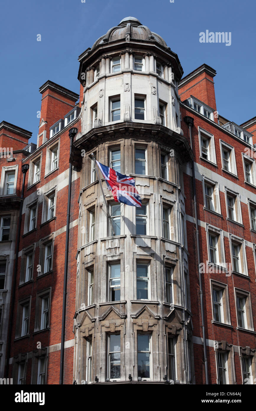 Tall historical building in London with a Union Jack flag hanging from ...