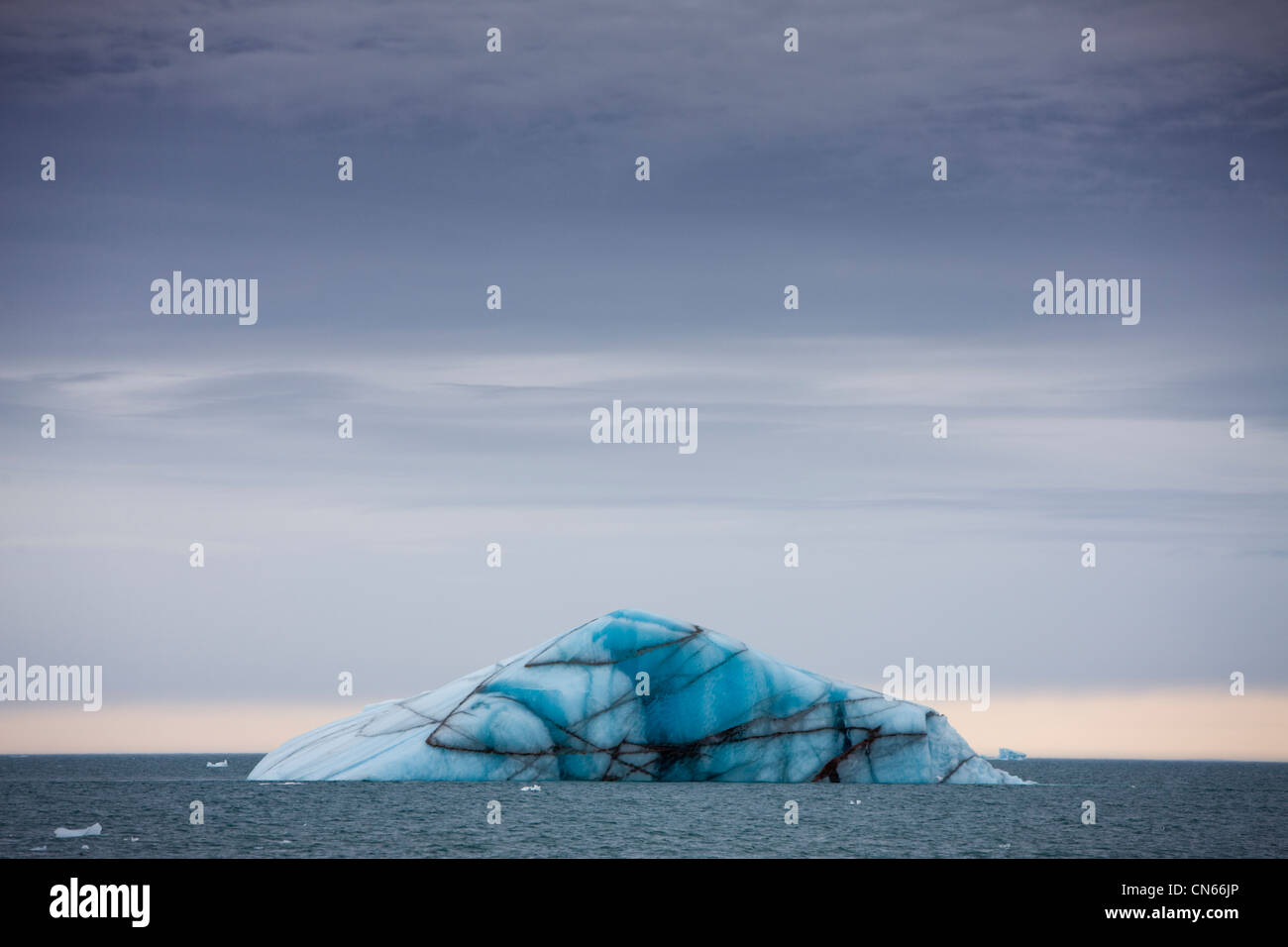 Norway, Svalbard, Nordaustlandet, Deep blue iceberg floating near face ...