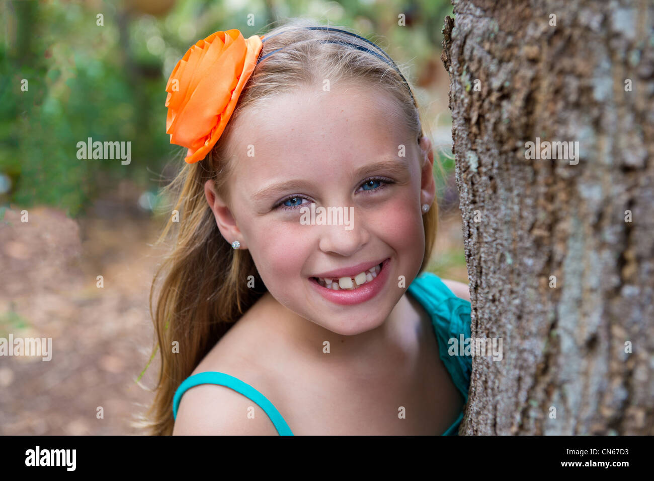 Portrait of happy 8 years old girl outdoors, looking at camera and ...